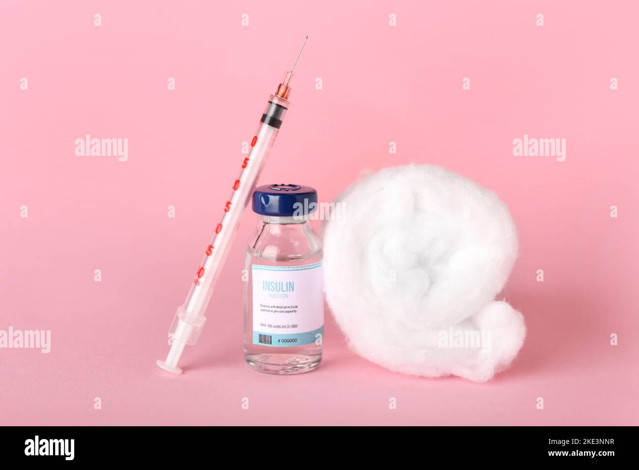 Roll of cotton wool, syringe and bottle of insulin on pink background ...