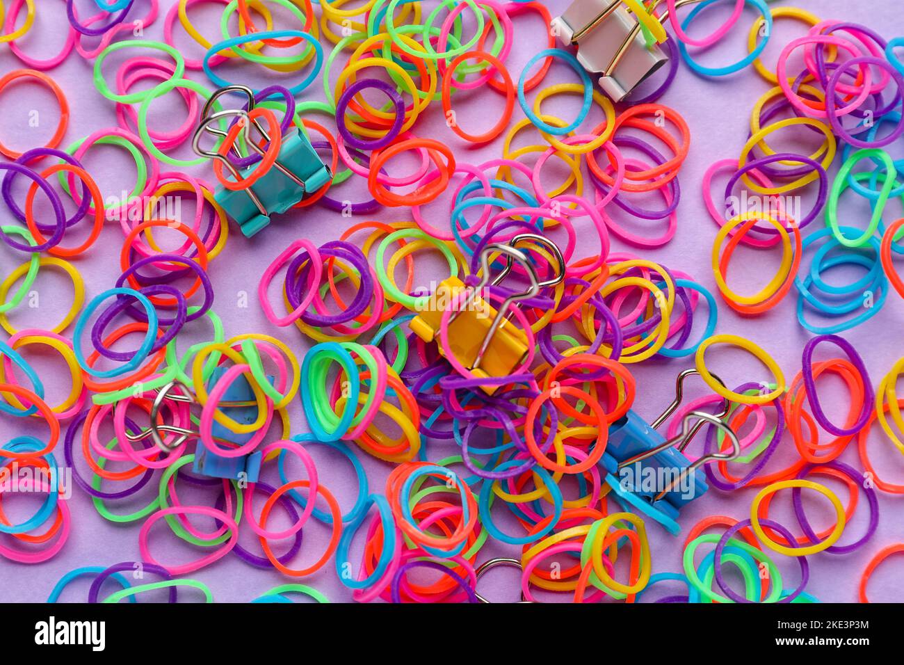 Colorful rubber bands and paper clips on lilac background Stock Photo ...