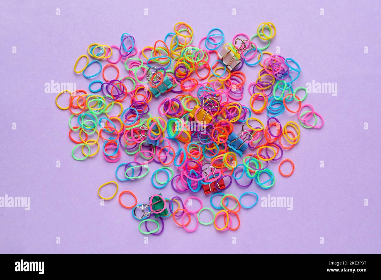 Colorful rubber bands and paper clips on lilac background Stock Photo ...