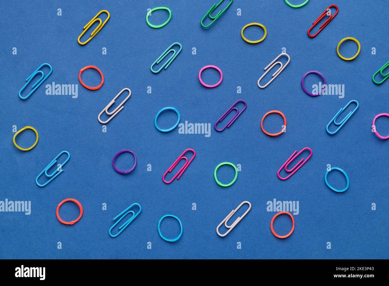 Rubber bands and paper clips on blue background Stock Photo - Alamy