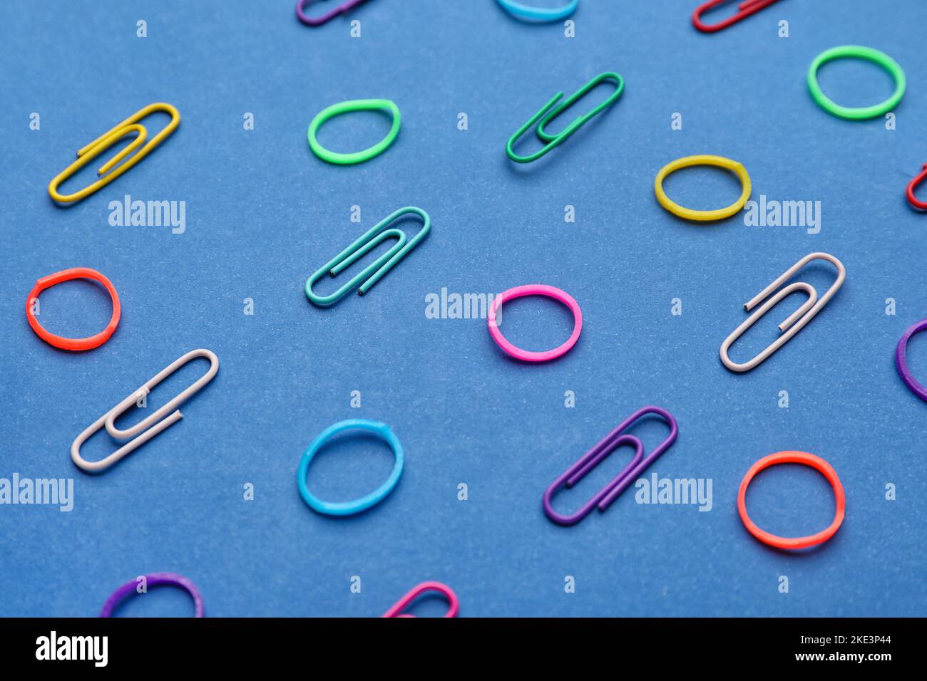 Rubber bands and paper clips on blue background Stock Photo - Alamy