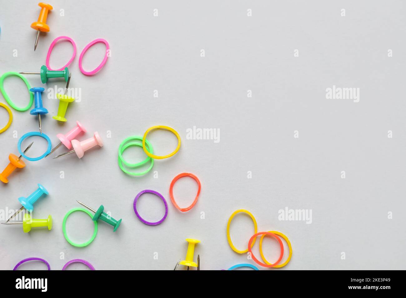 Colorful rubber bands and pushpins on white background Stock Photo - Alamy