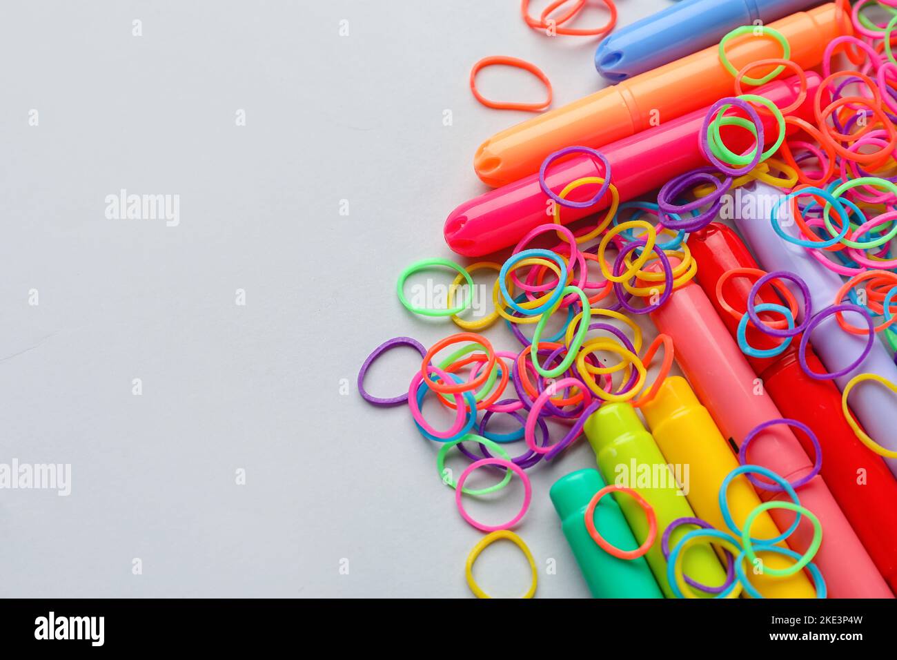 Colorful rubber bands and markers on white background Stock Photo - Alamy