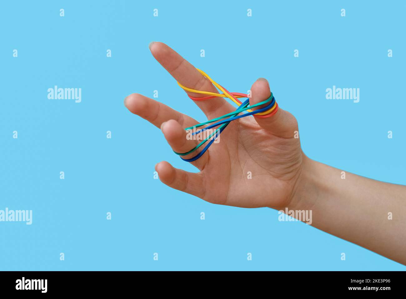 Woman with rubber bands on blue background Stock Photo - Alamy