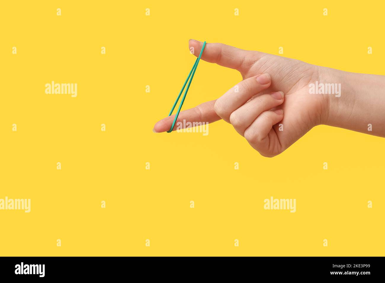 Woman with green rubber band on yellow background Stock Photo - Alamy