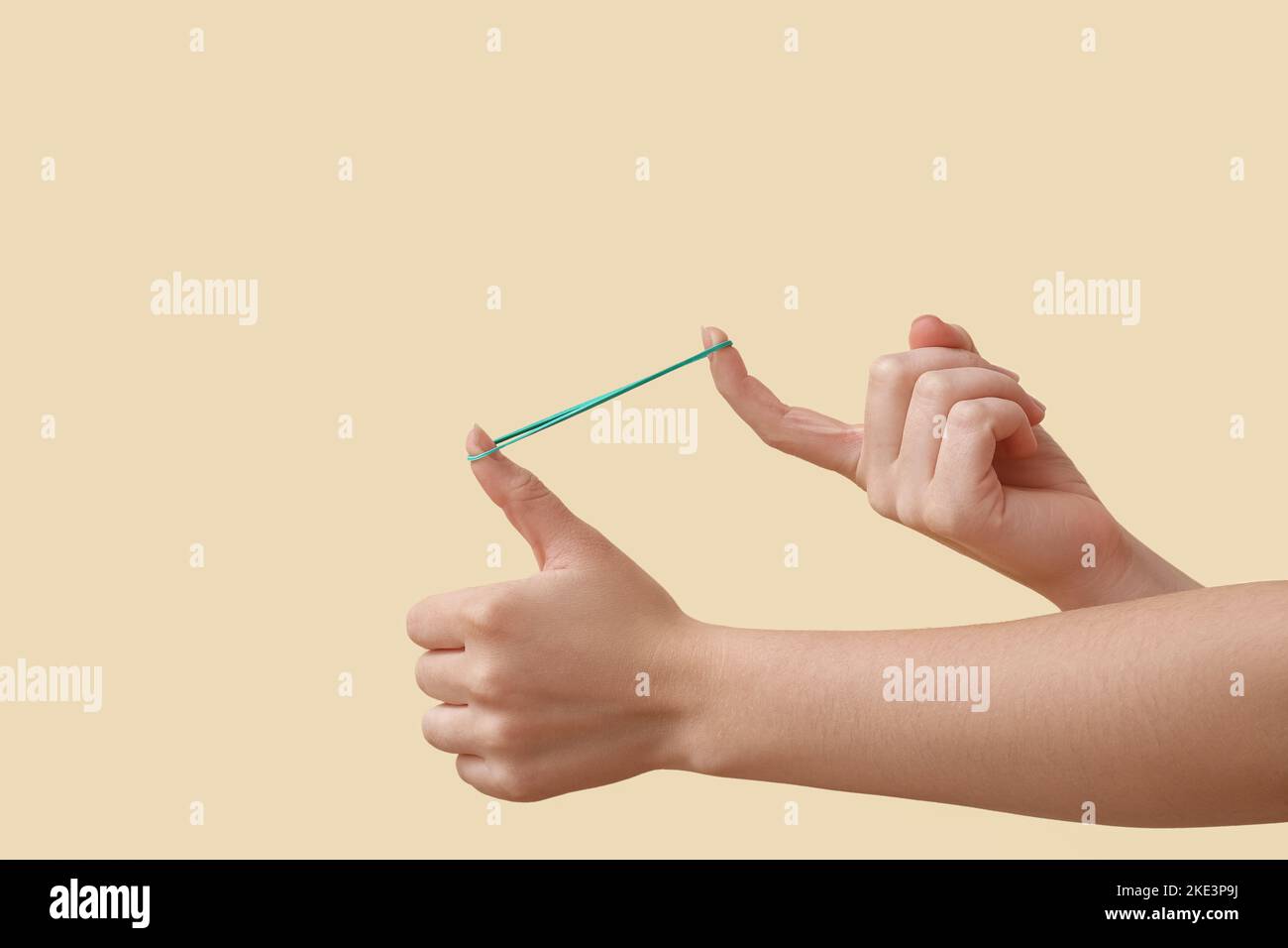 Woman with green rubber band on beige background Stock Photo - Alamy