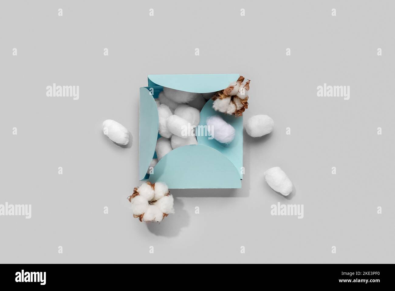Box with soft cotton balls and flowers on grey background Stock Photo ...