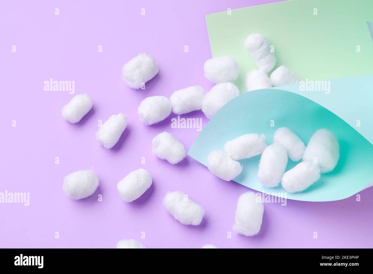 Paper sheets with cotton balls on lilac background Stock Photo - Alamy