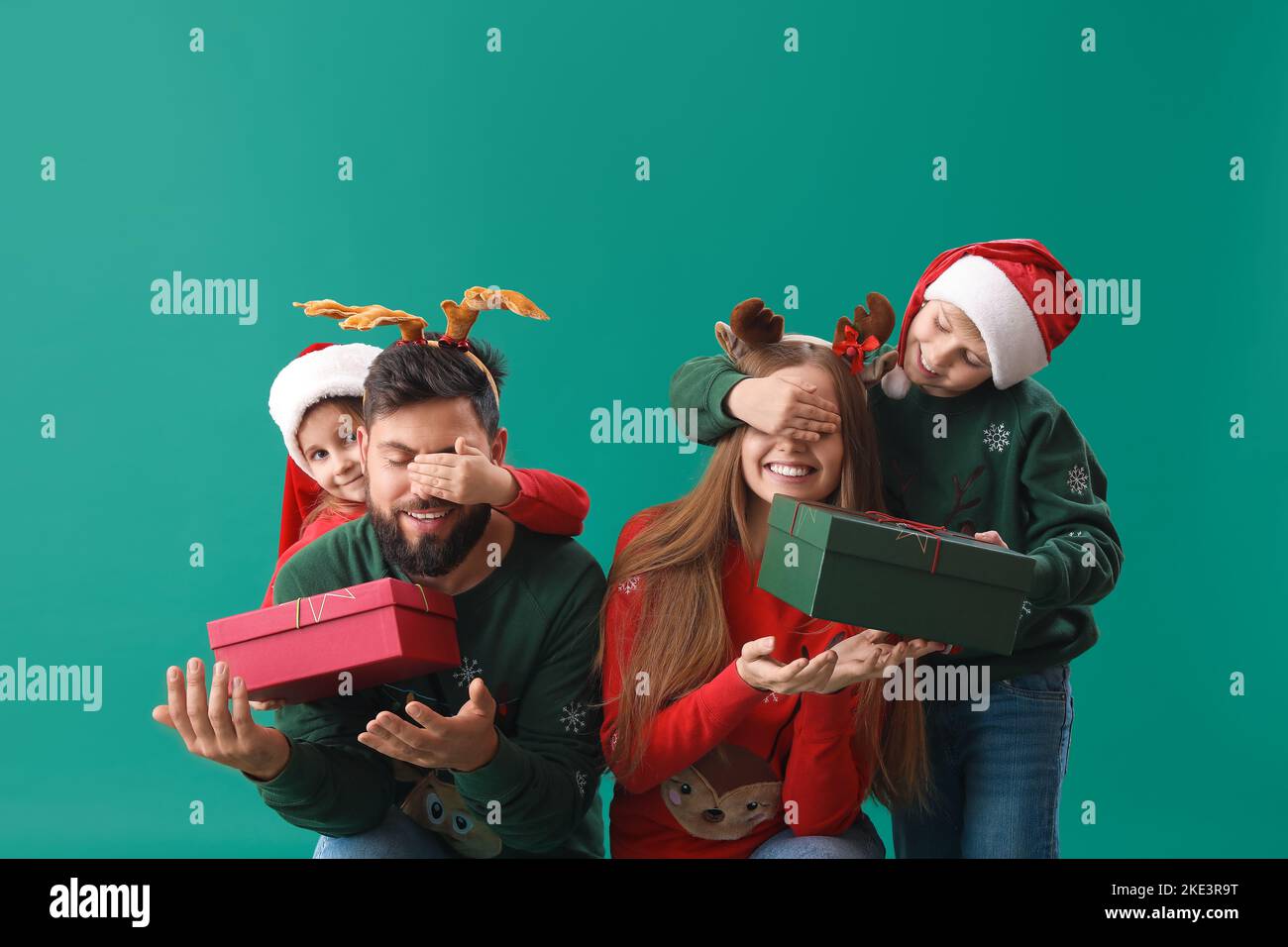 Little children surprising their parents with Christmas gifts on green ... Little children surprising their parents with Christmas gifts on green ...