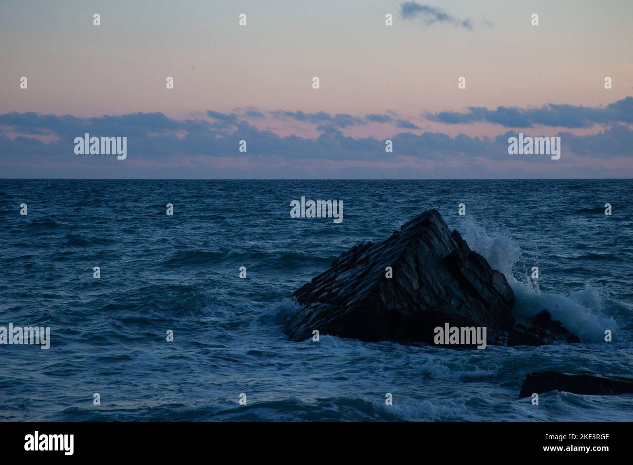 Sharp Rock Protruding from the Sea with the Waves Crashing into it ...