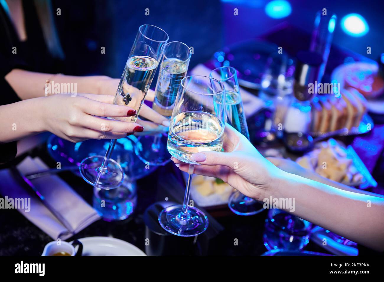 Girls in a nightclub clink glasses with alcoholic drinks Stock Photo ...