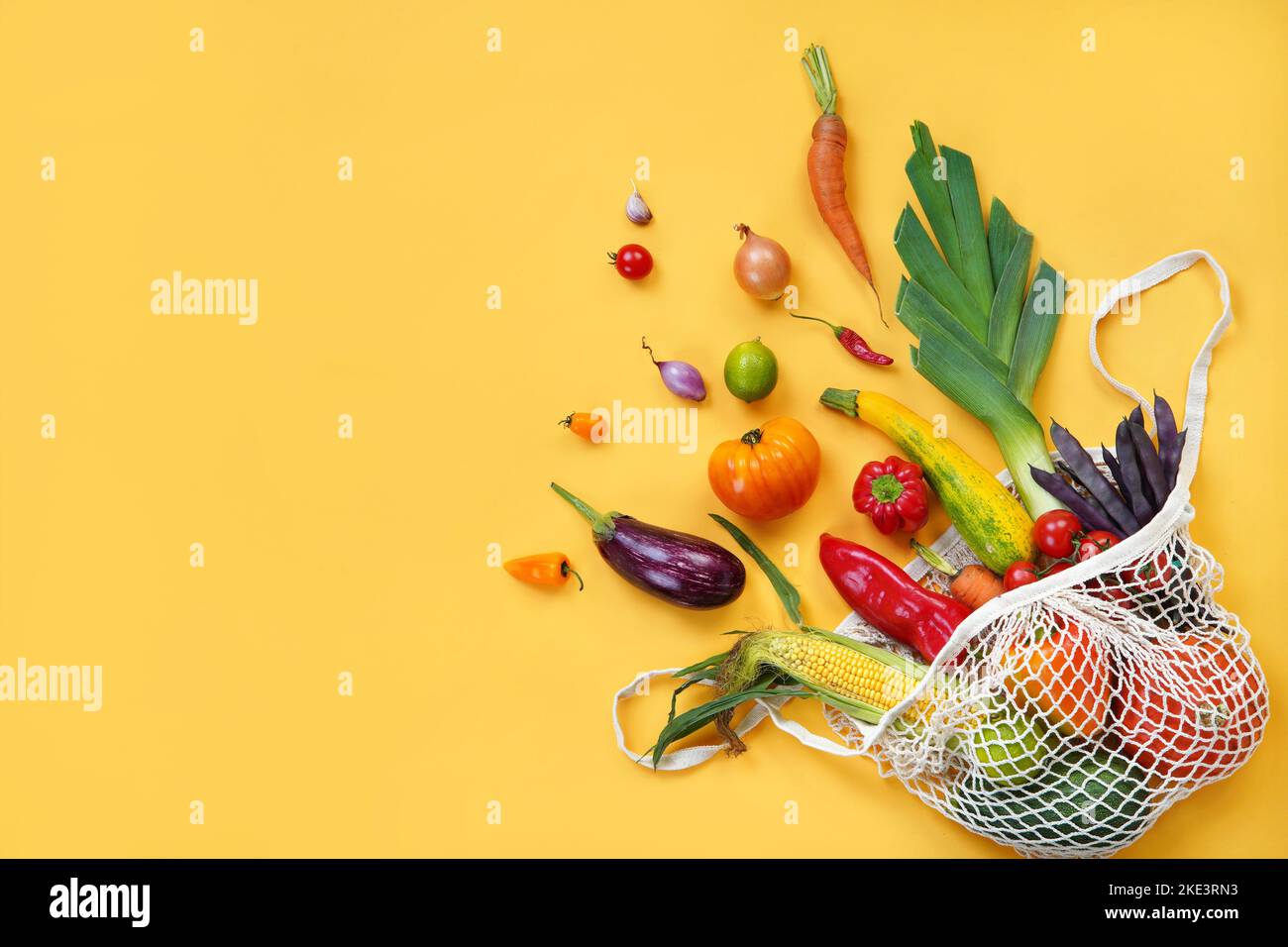 String bag with vegetables on yellow background. Copy space. Top view ...