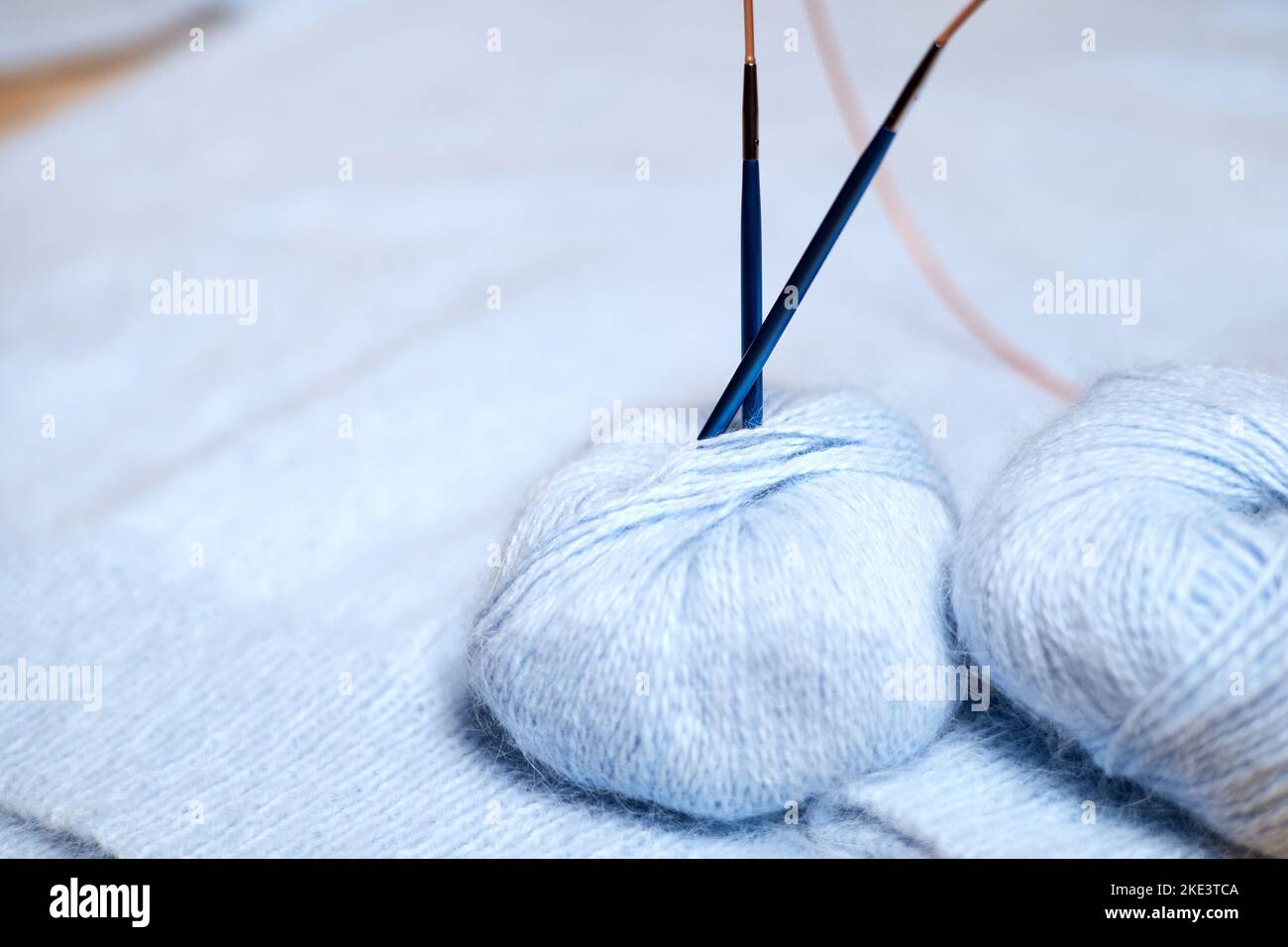 Blue knitted women's sweater with patterns, balls of thread and ...