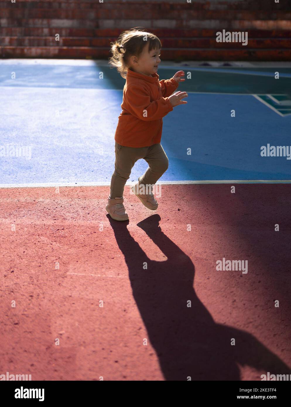 Female toddler running and playing outside Stock Photo - Alamy