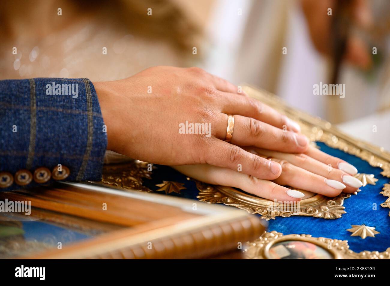 The bride and groom hold each other's hands during a church wedding ...