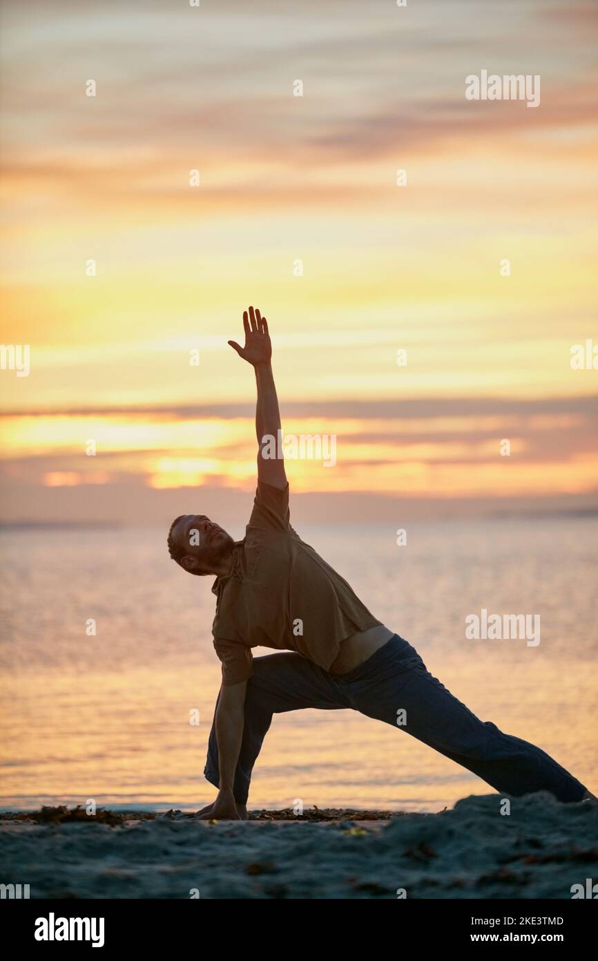 Yoga - bind the body and mind. a man practicing the triangle pose ...