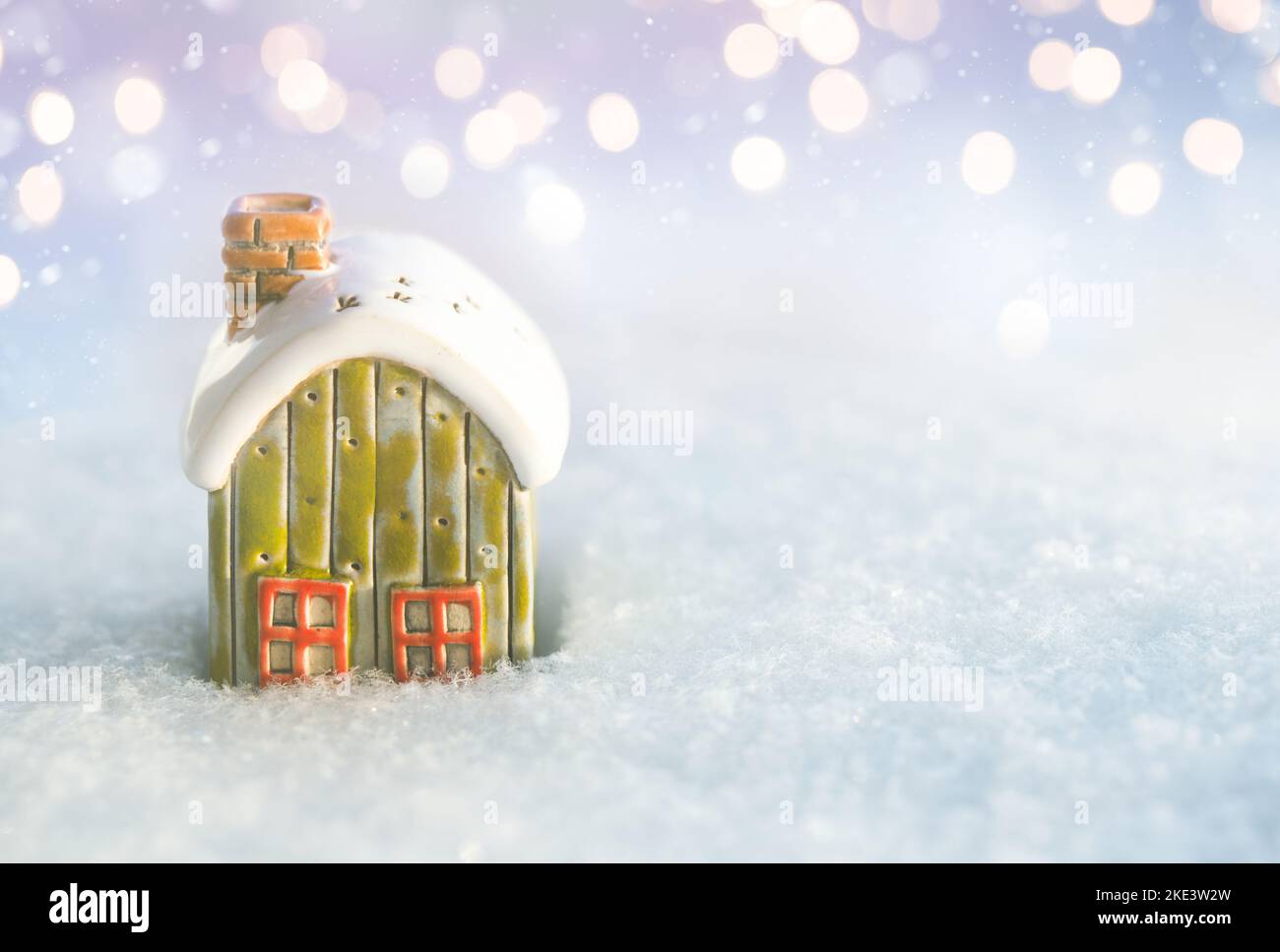 Festive white background with toy house on snow Stock Photo - Alamy