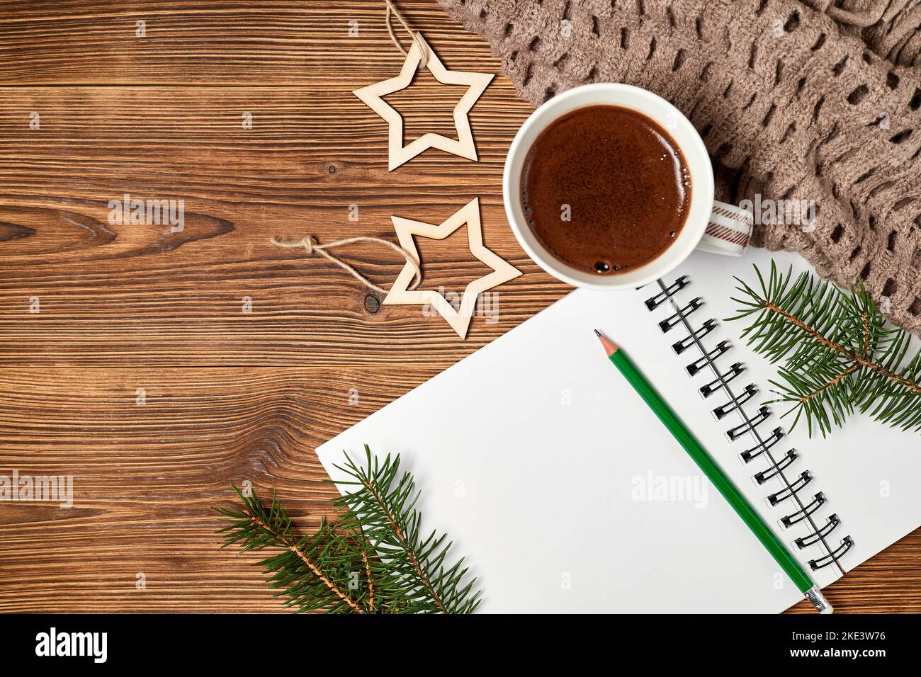 Christmas composition of open blank notepad, coffee cup, scarf and fir ...