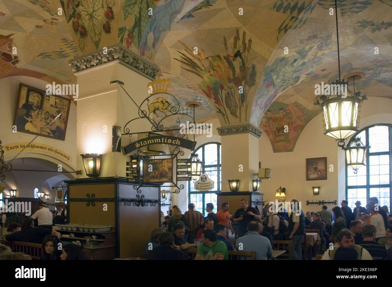 People drink beer at the famous old Hofbrauhaus beer hall in the city ...
