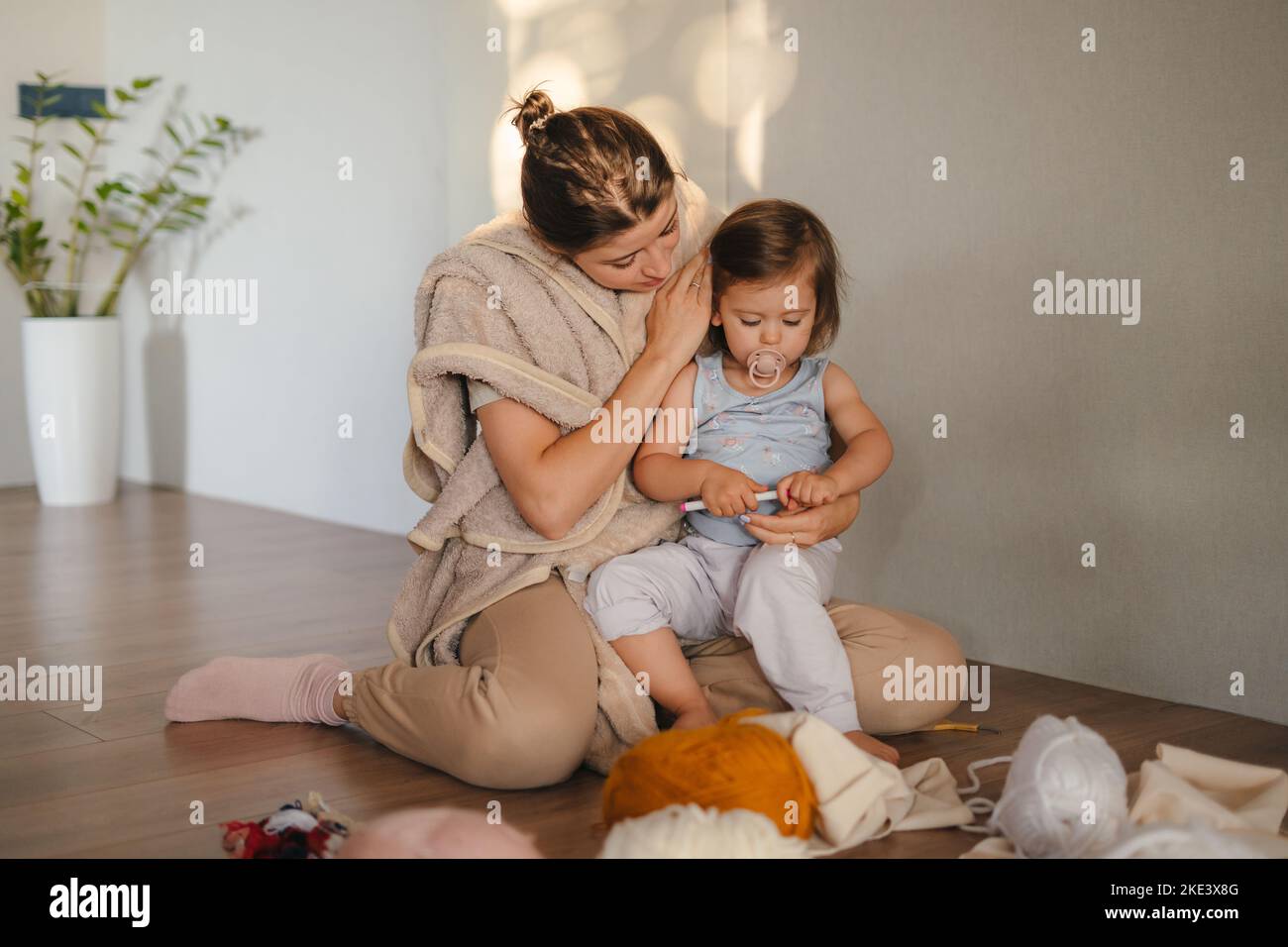 The mother taking care of the development of her baby daughter's skills, practicing different ...