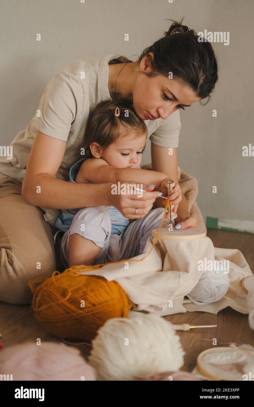 Beautiful mother teaching her daughter how to knitting patterns for the ...