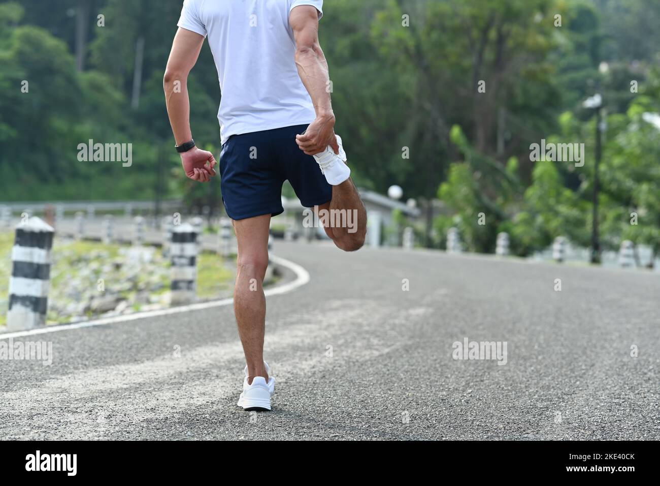 Back view of sportsman man stretching his leg, preparing for morning ...