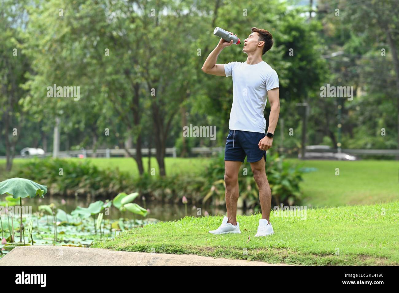 Handsome athletic male drinking water from plastic bottle, resting ...