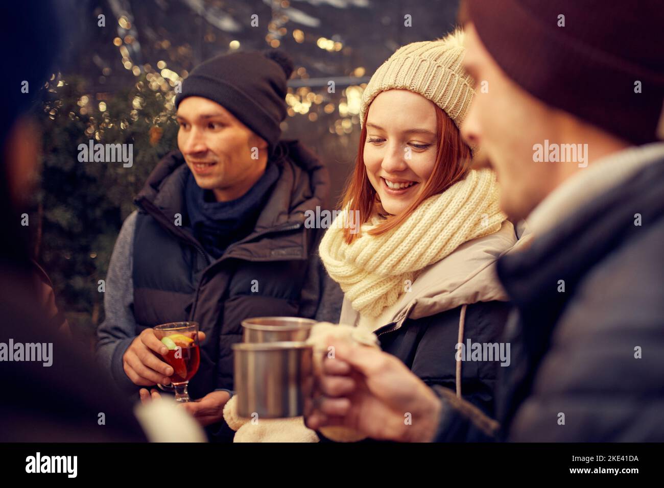 Group of young people spending time together, drinking mulled wine ...