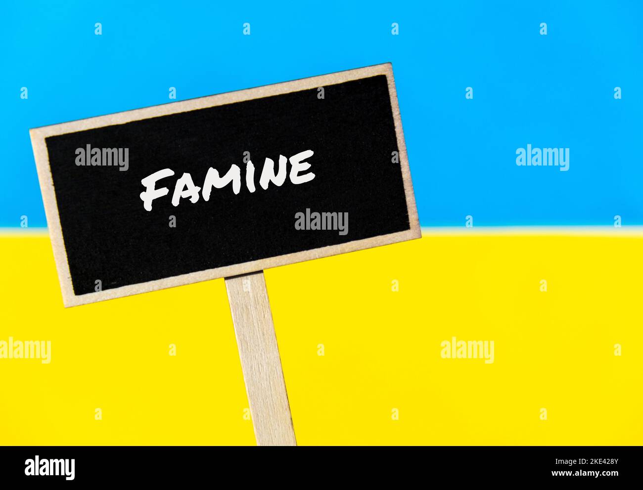 Wooden information label sign with text FAMINE against Ukrainian ...