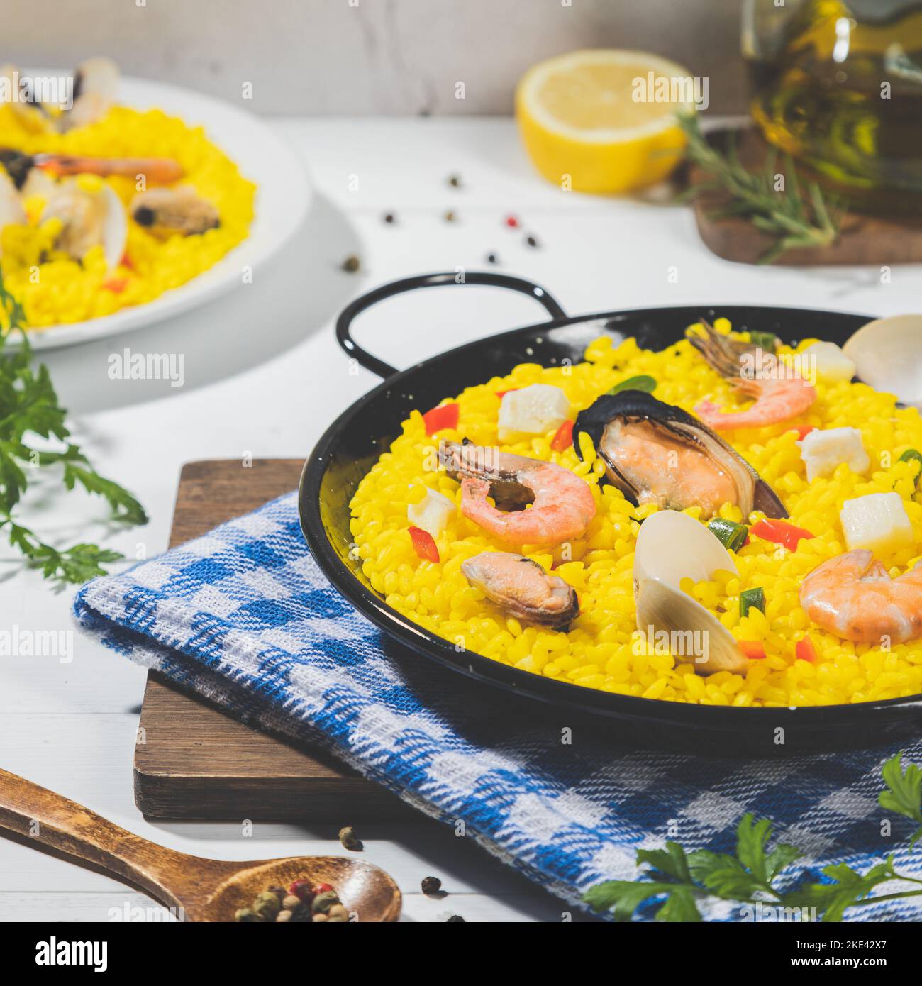 Seafood paella on traditional pan paella on white wood base. Square ...