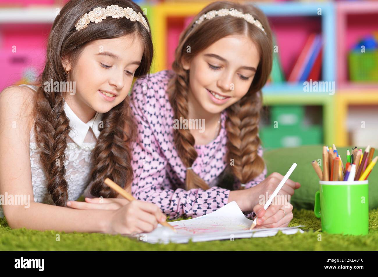 Beautiful little girls draws with a pencil on a sheet of paper Stock ...