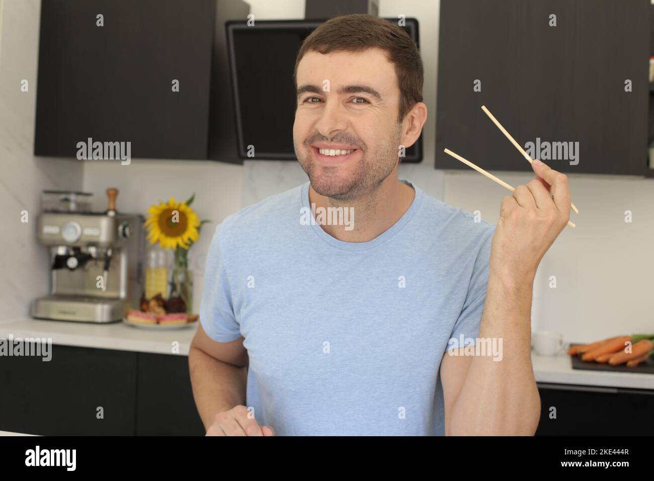 Man ready to eat with pair of chopsticks Stock Photo - Alamy