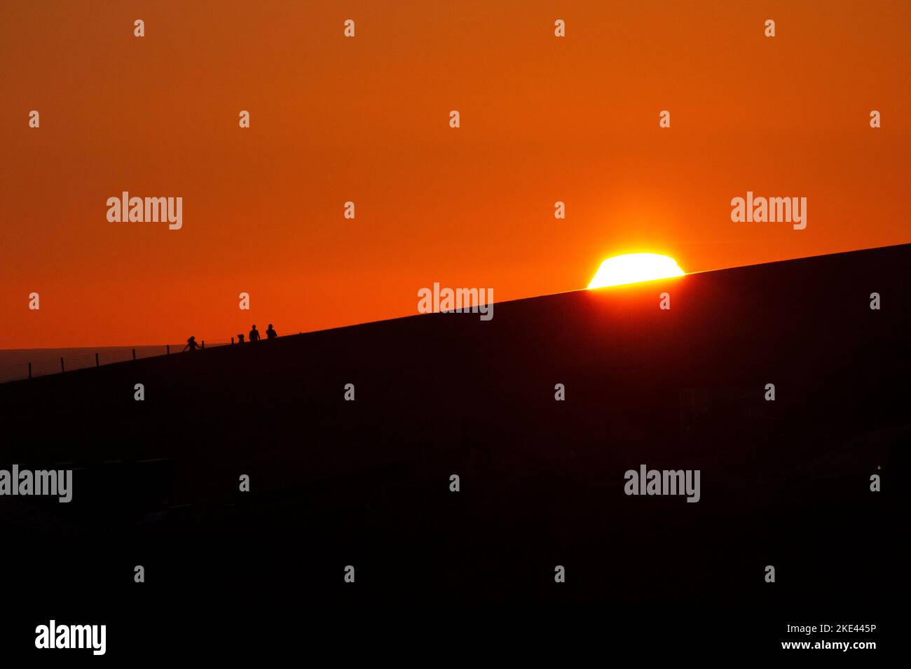 People watch the sunset from the South, West Coastal Path near Mawgan ...