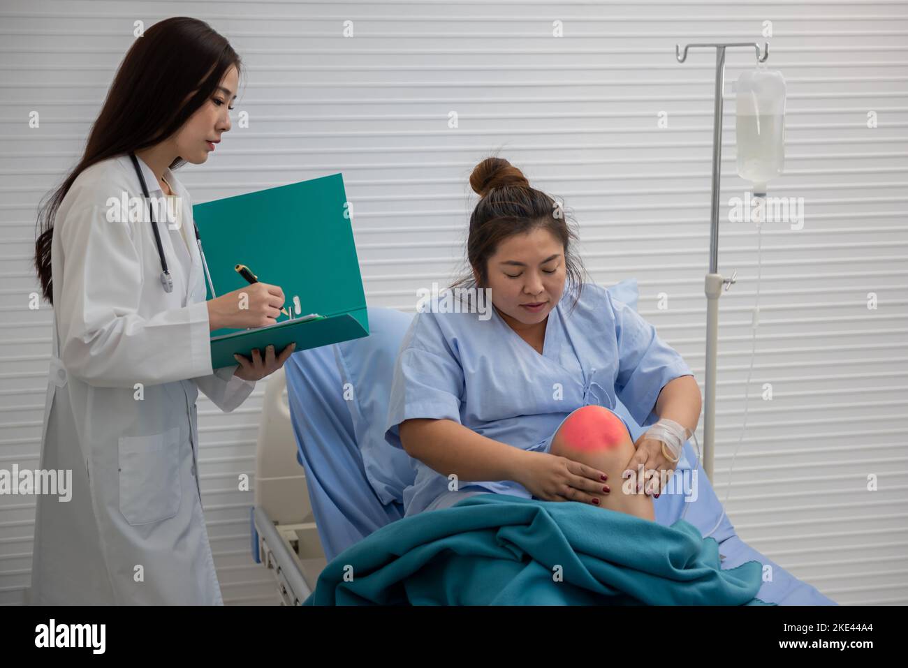 Female doctor with overweight woman sitting on the bed holding on her ...