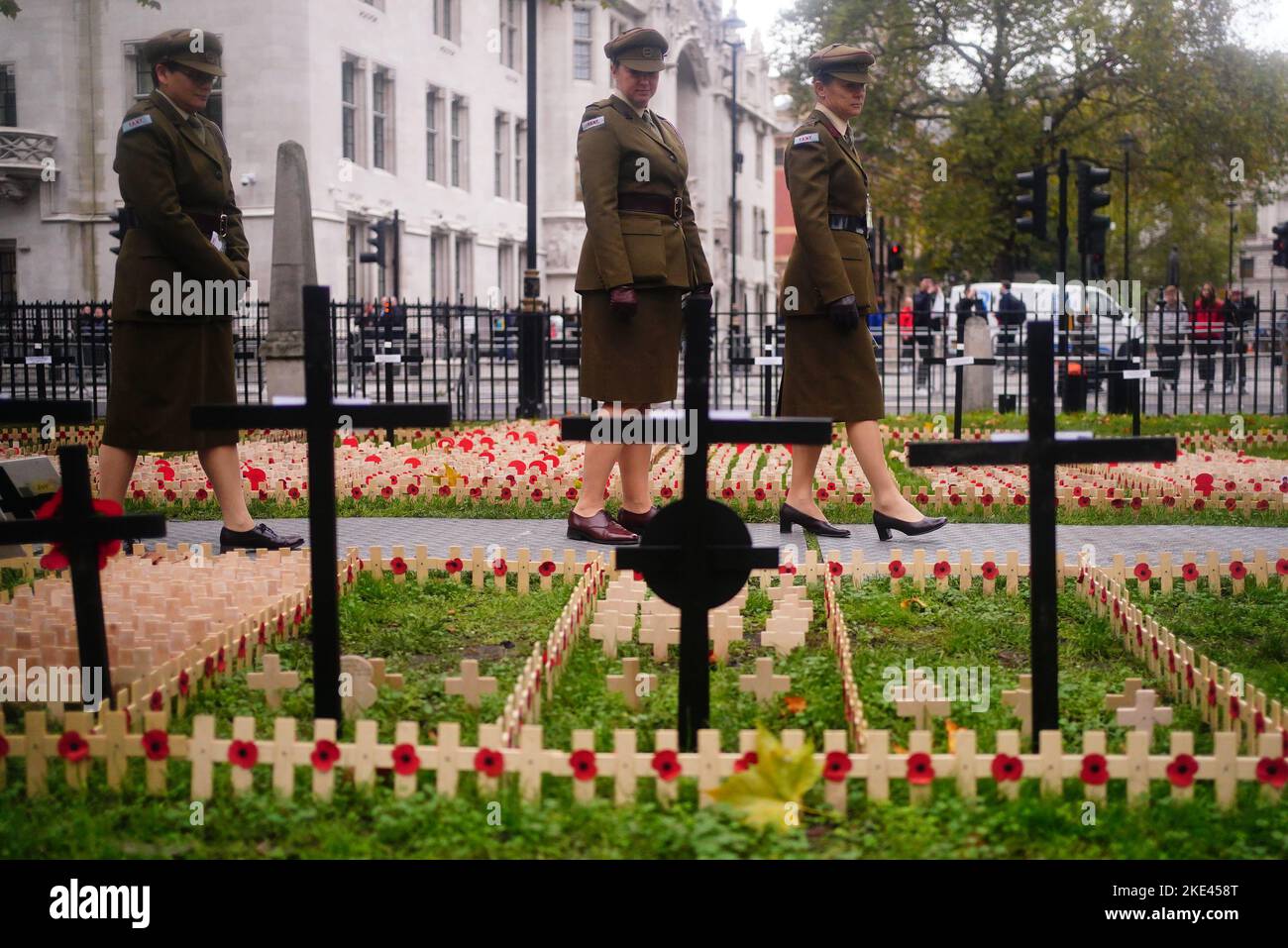 Members of the military looks at messages and crosses on display at the ...