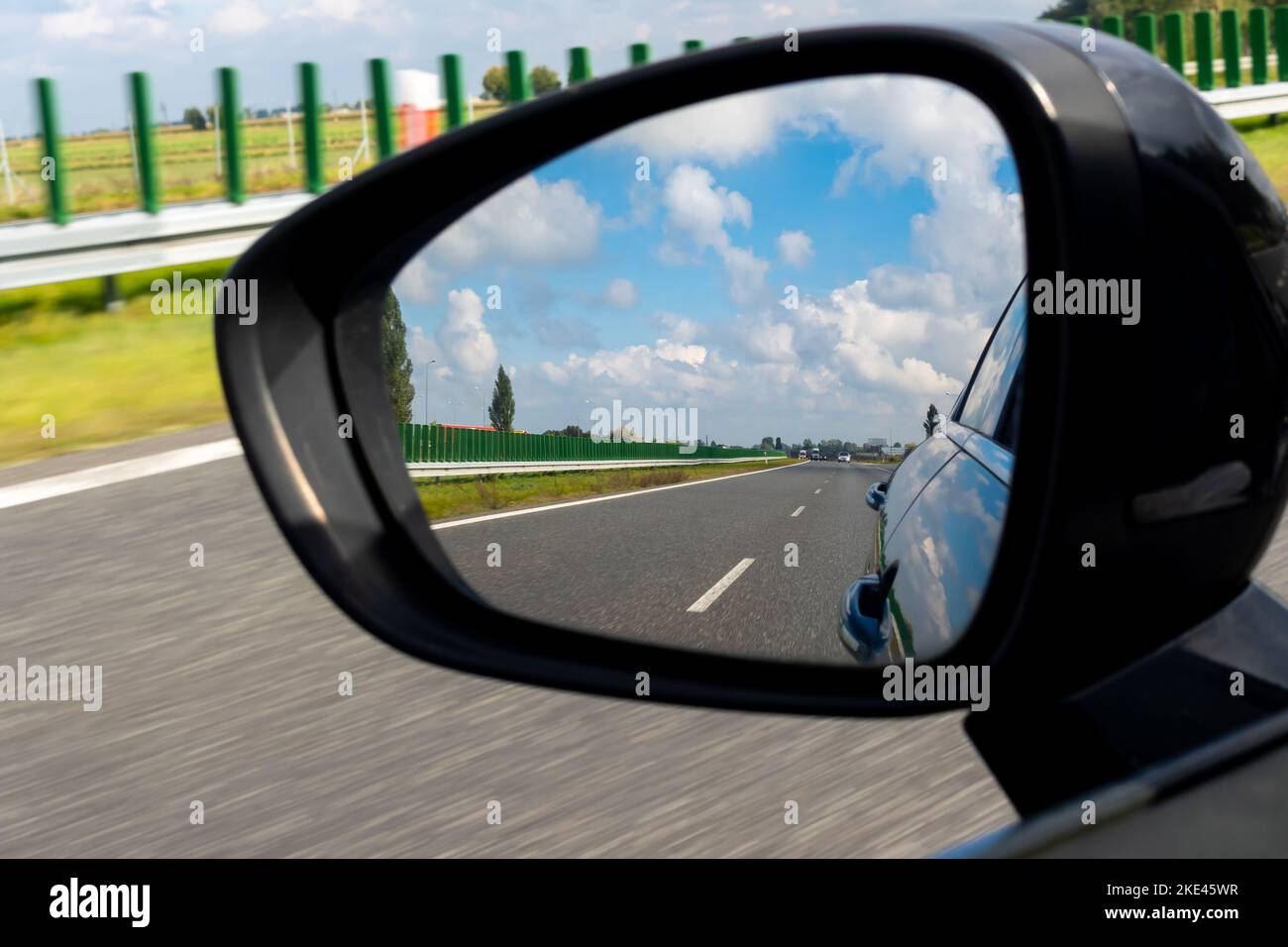 View in the side rearview mirror of a passenger car. Photo taken while ...