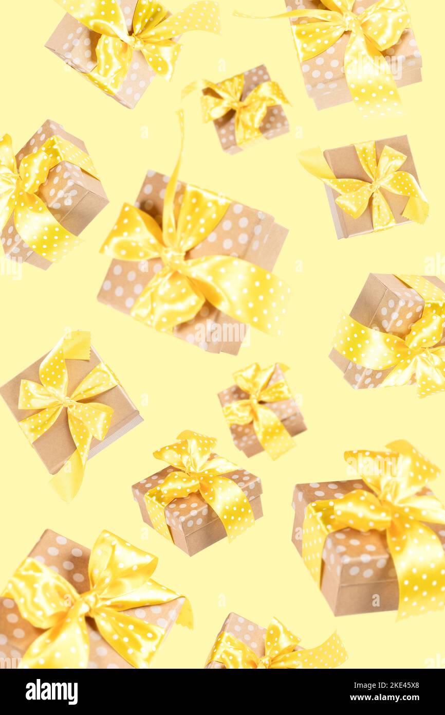 Wrapped gift boxes decorated with yellow ribbons and bows falling ...