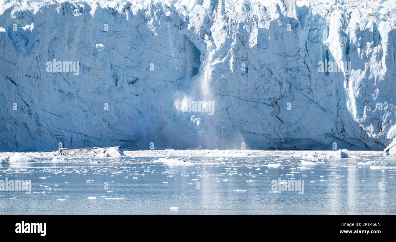 A piece of an icy land covered with snow and a frozen sea in front of ...