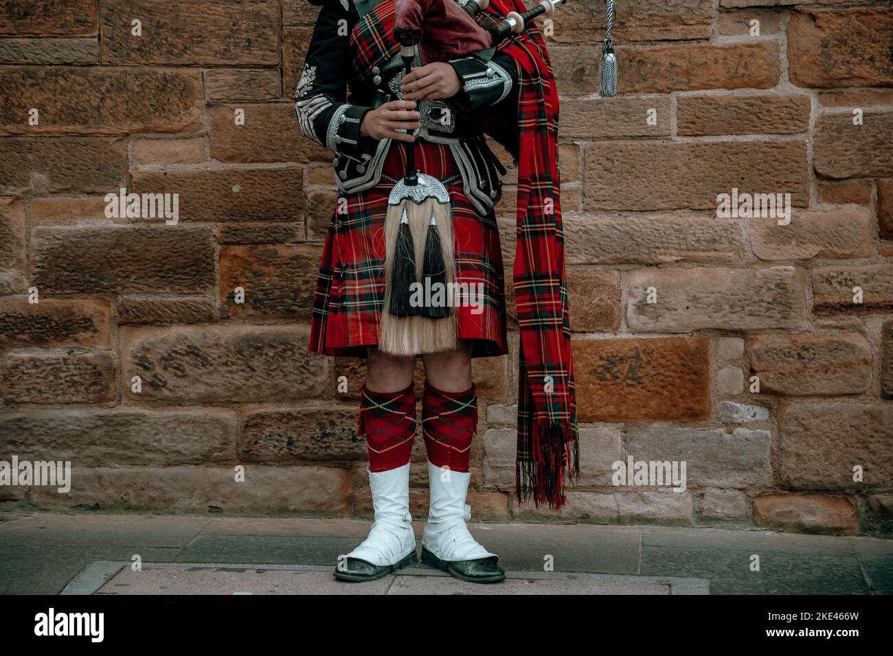 A male wearing traditional Scottish kilt and standing in front of wall ...