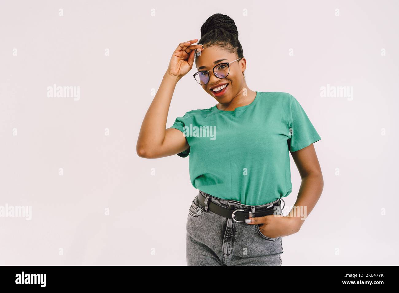 Expressive black woman in green shirt with jean smiling and happy on ...