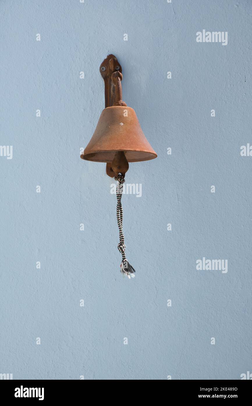 An old hanging old bell from blue wall Stock Photo - Alamy