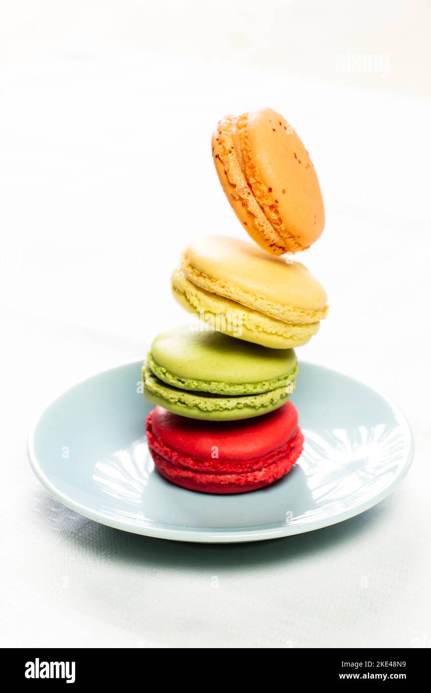 Falling macarons pastries on a seamless white background Stock Photo ...