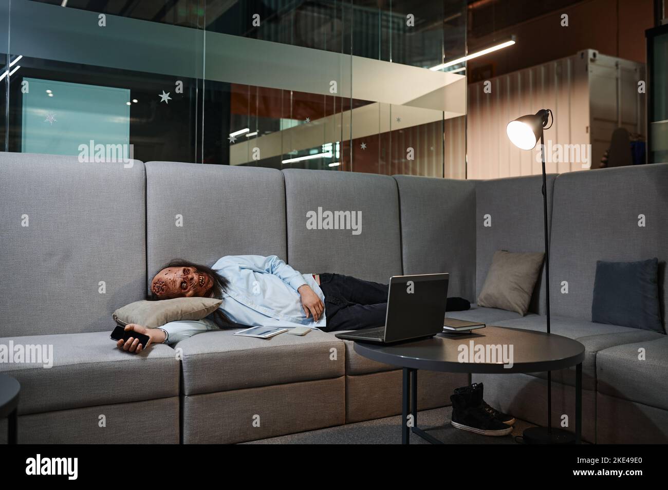 Overworked zombie sleeping on sofa in office Stock Photo - Alamy