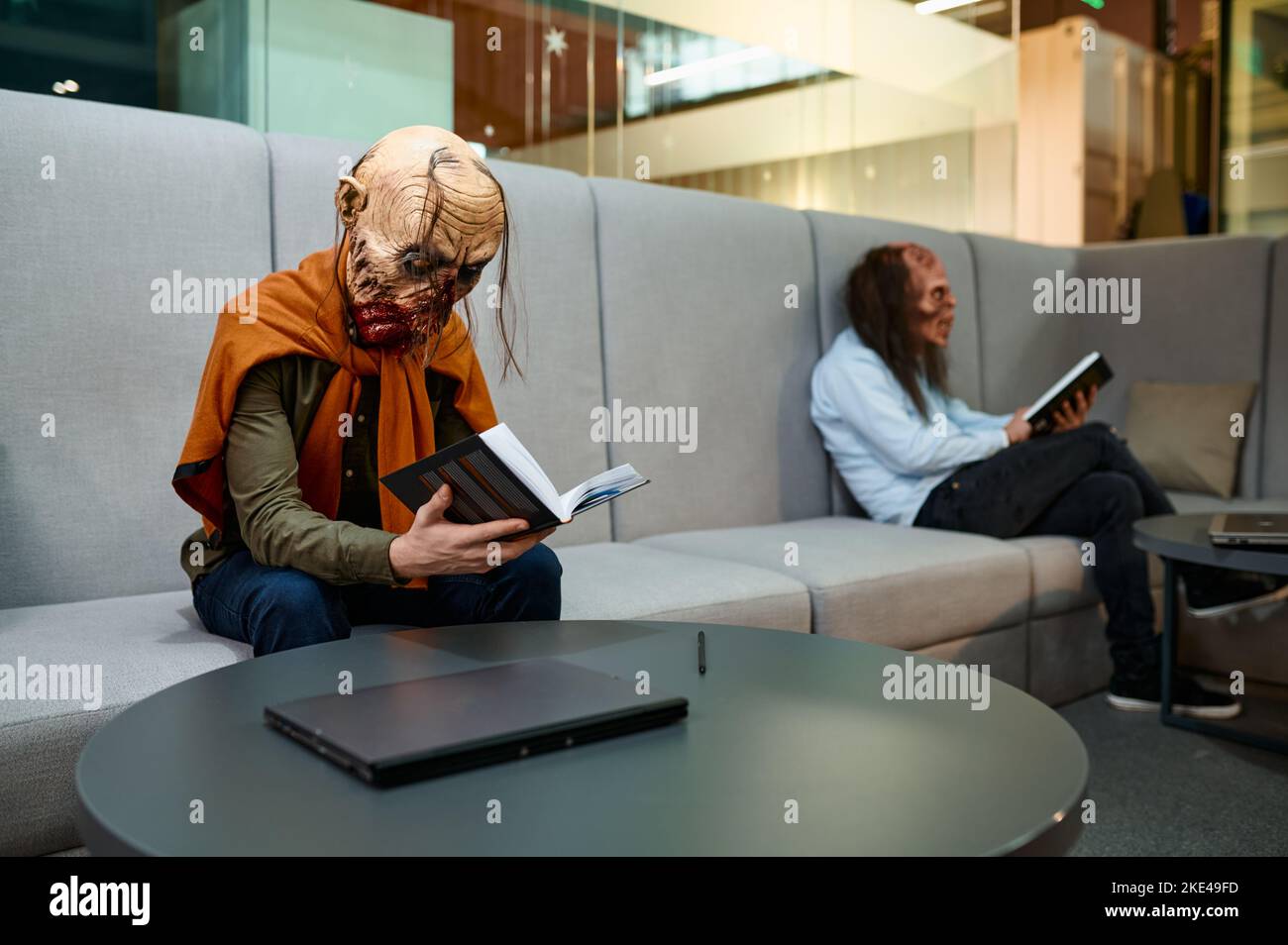 Zombie employees reading sitting on sofa Stock Photo - Alamy