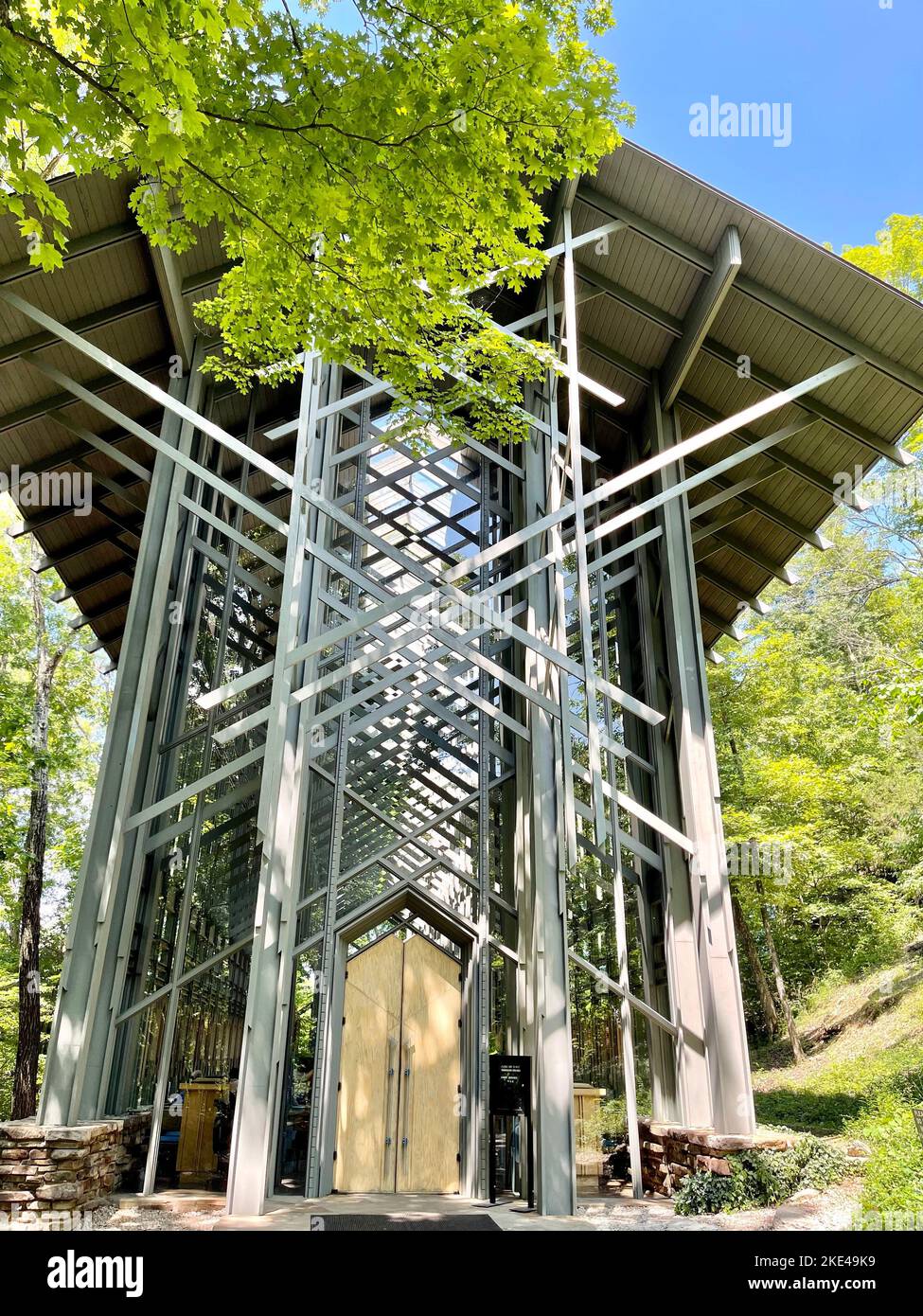 A vertical shot of the Thorncrown Chapel in Arkansas with trees in the ...