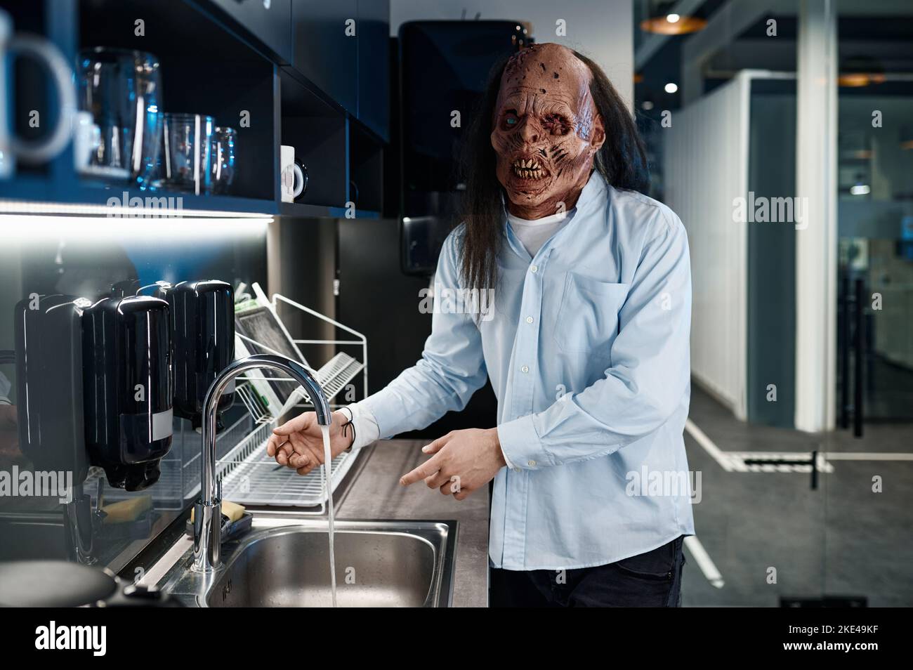 Creepy zombie employee washing cup in sink Stock Photo - Alamy