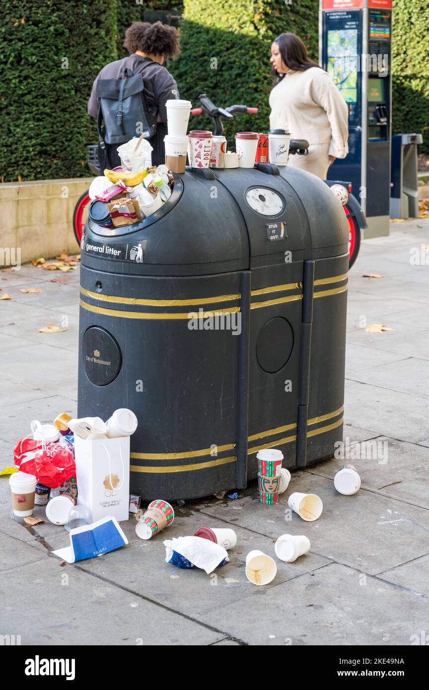 Overspilling municipal litter bin in Green Park, London, England, UK ...