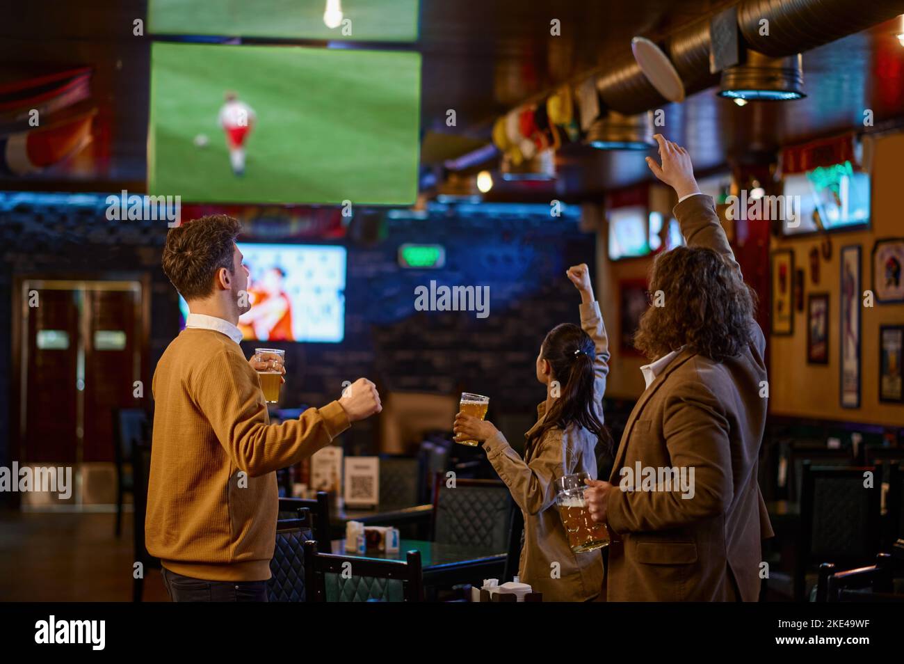 Happy football fans cheering drinking beer and watching soccer match ...