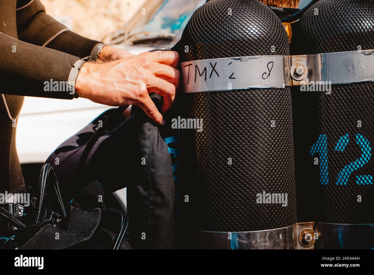 A male holding tanks (gas cylinders) with valves, getting prepared for ...