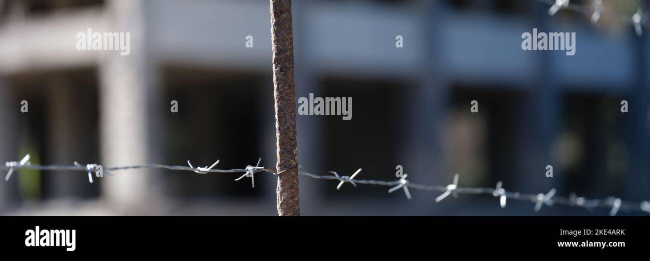 Barbed wire fence in front of prison building closeup Stock Photo - Alamy